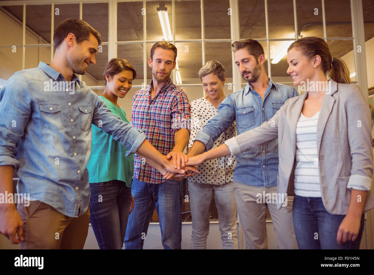 Creative business team putting their hands together Stock Photo - Alamy