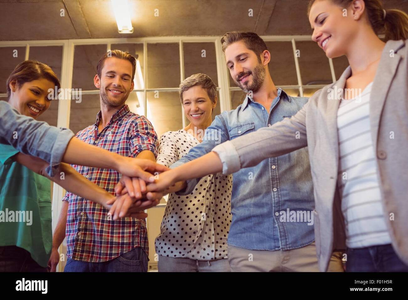 Creative business team putting their hands together Stock Photo - Alamy