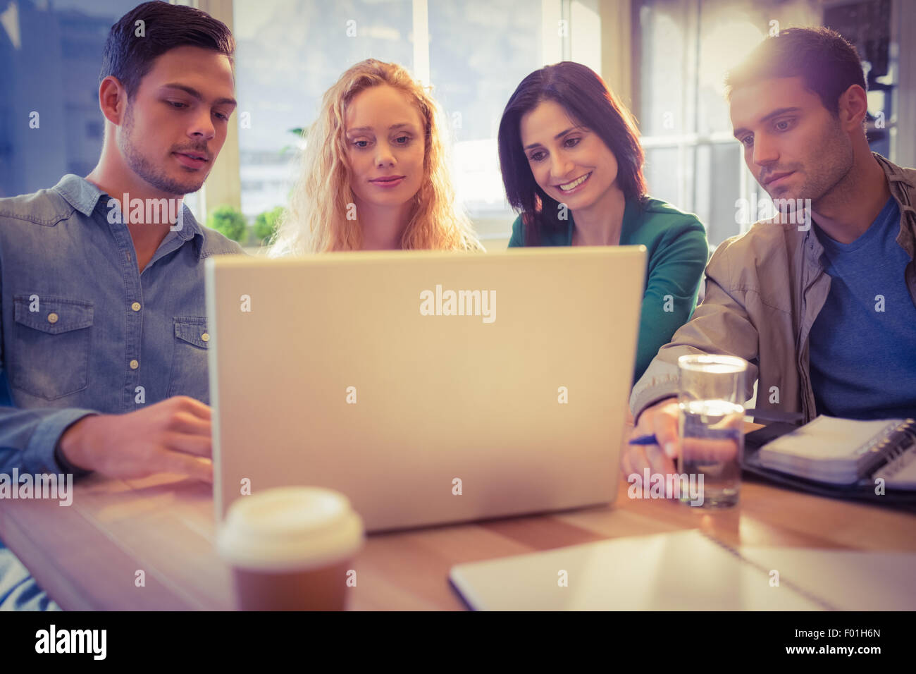 Group of young colleagues using laptop Stock Photo - Alamy