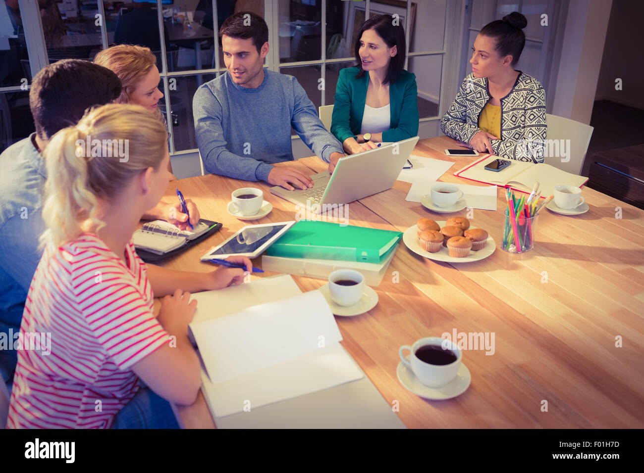 Group of young colleagues using laptop Stock Photo - Alamy