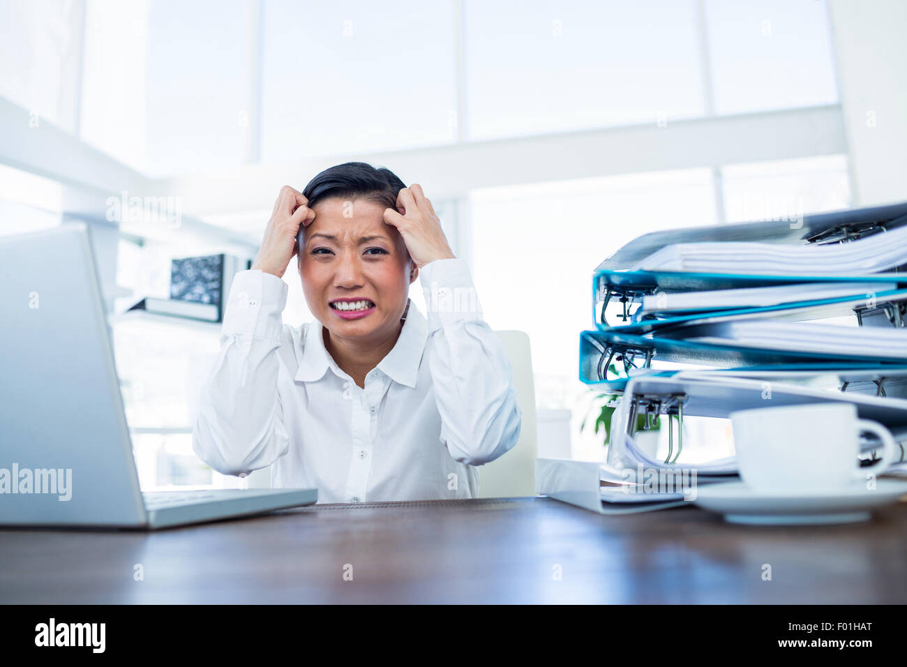 Businesswoman getting stressed at her desk Stock Photo - Alamy