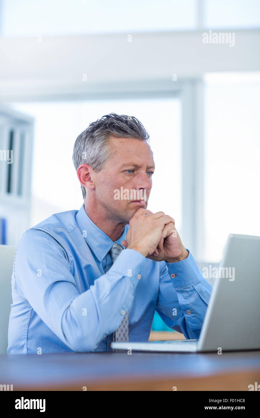 Concentrated businessman looking at laptop computer Stock Photo - Alamy