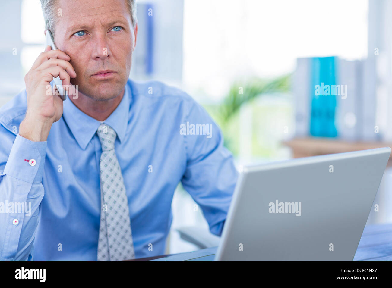 Serious businessman having phone call Stock Photo - Alamy