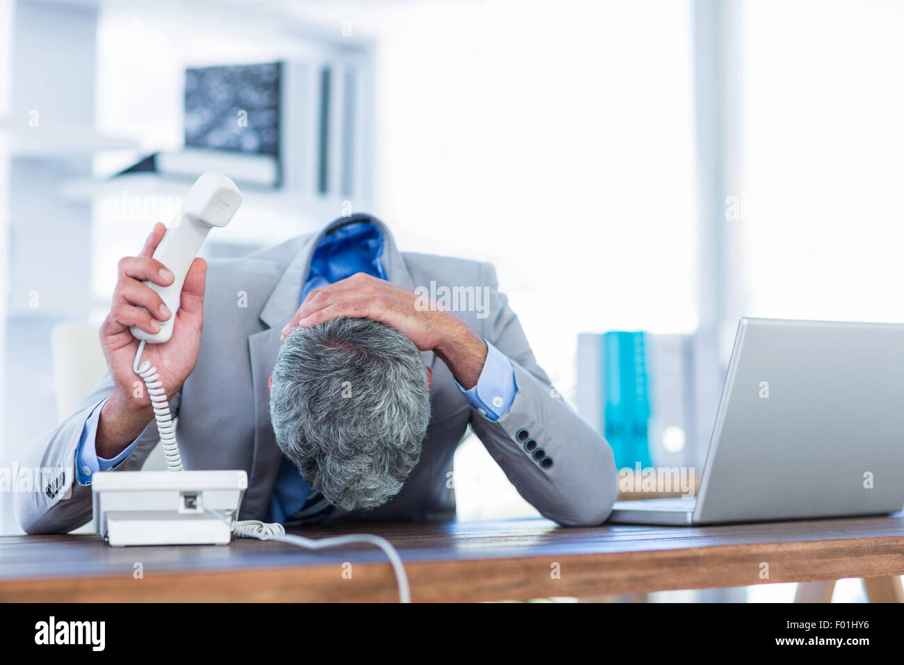 Depressed businessman holding phone Stock Photo - Alamy