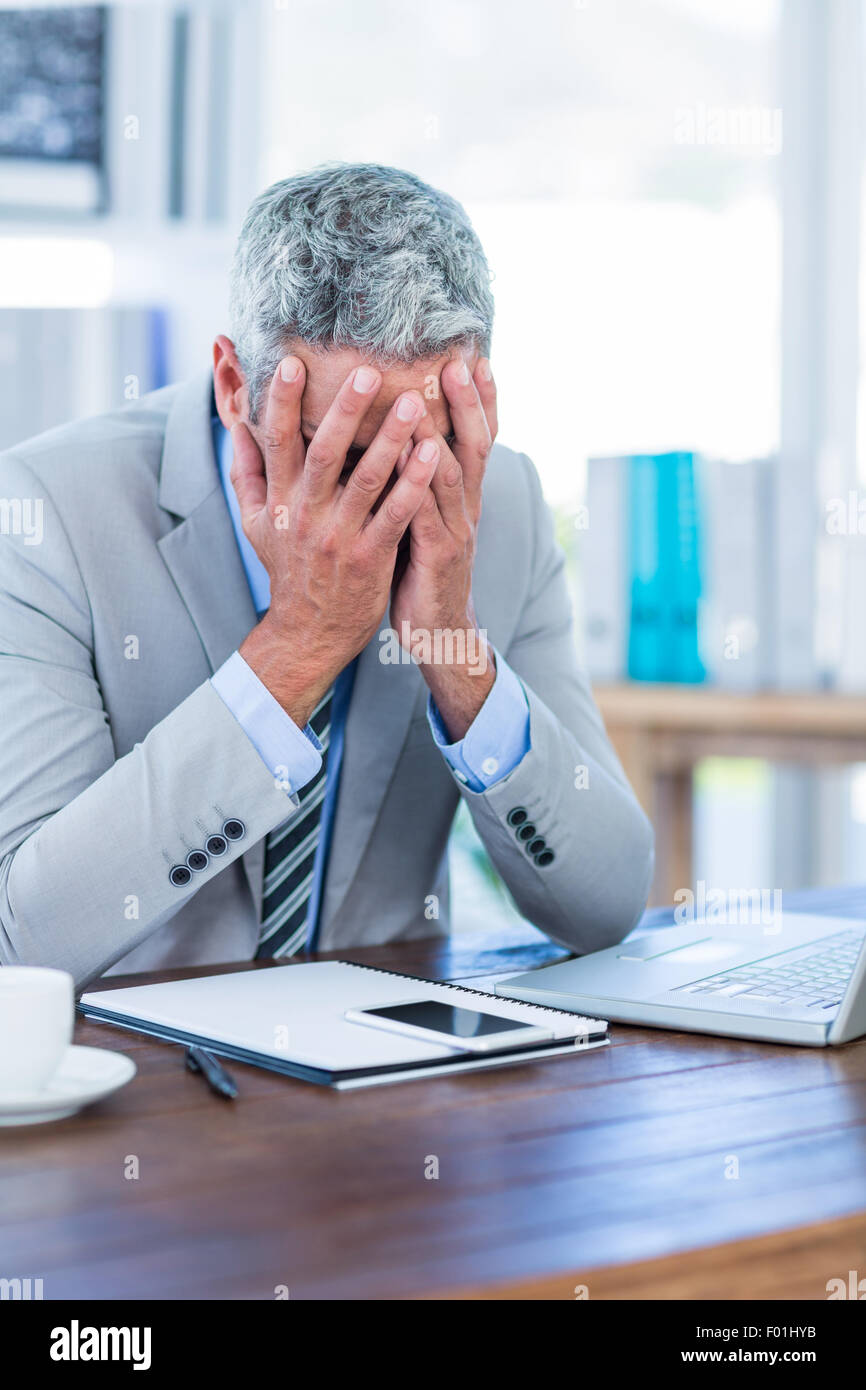 Depressed businessman with hands on head Stock Photo - Alamy