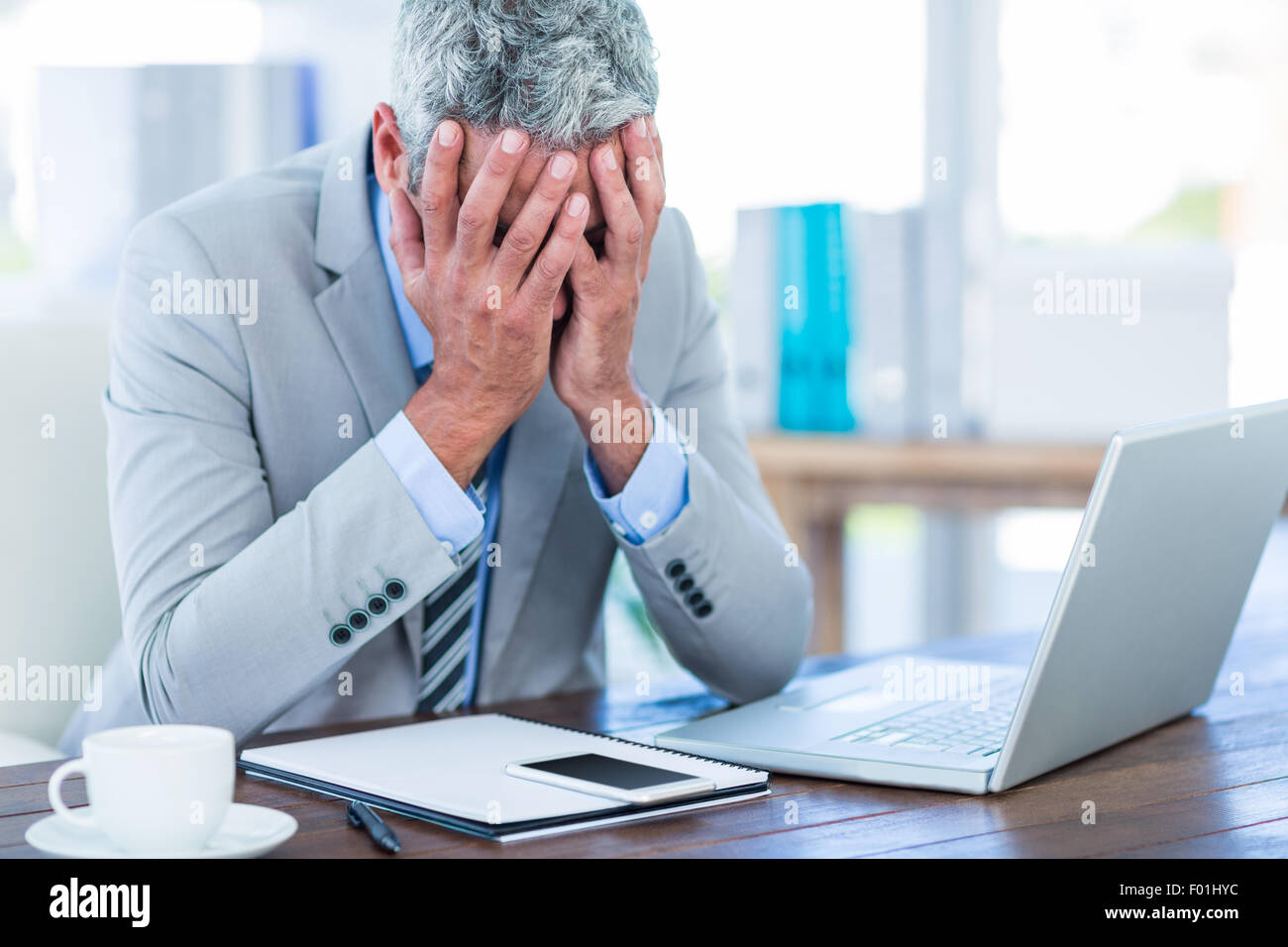 Depressed businessman with hands on head Stock Photo - Alamy