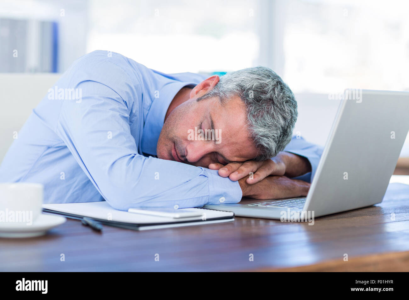 Businessman sleeping on laptop computer Stock Photo - Alamy