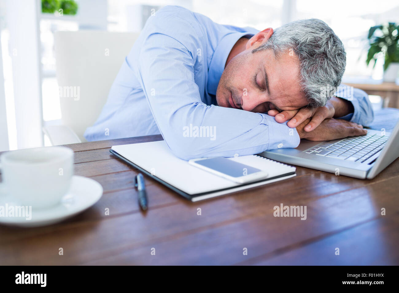 Businessman sleeping on laptop computer Stock Photo - Alamy