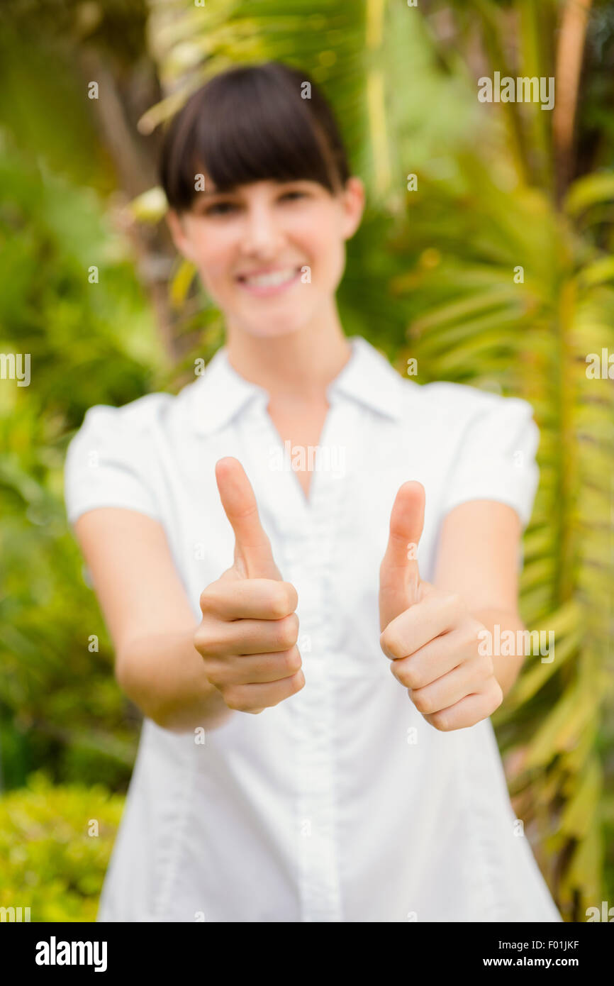 Pretty woman gesturing thumbs up before spa day Stock Photo - Alamy