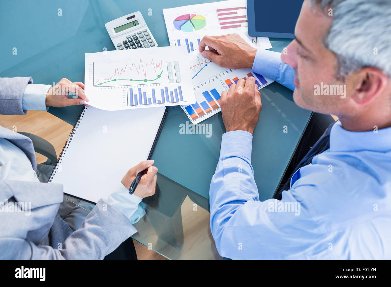 Business people looking at documents with graphics Stock Photo - Alamy