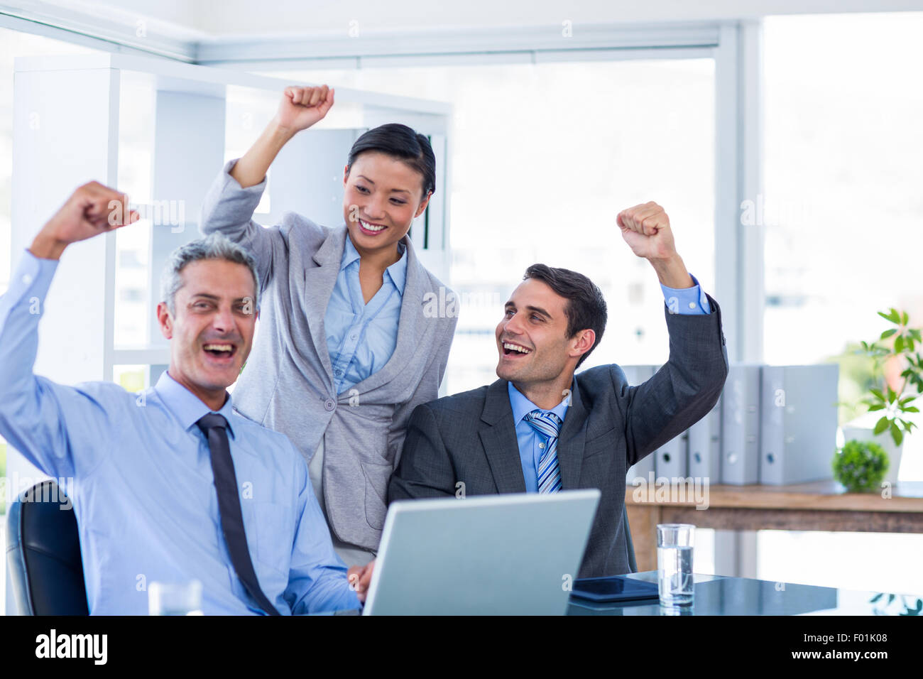 Happy business people cheering together Stock Photo - Alamy