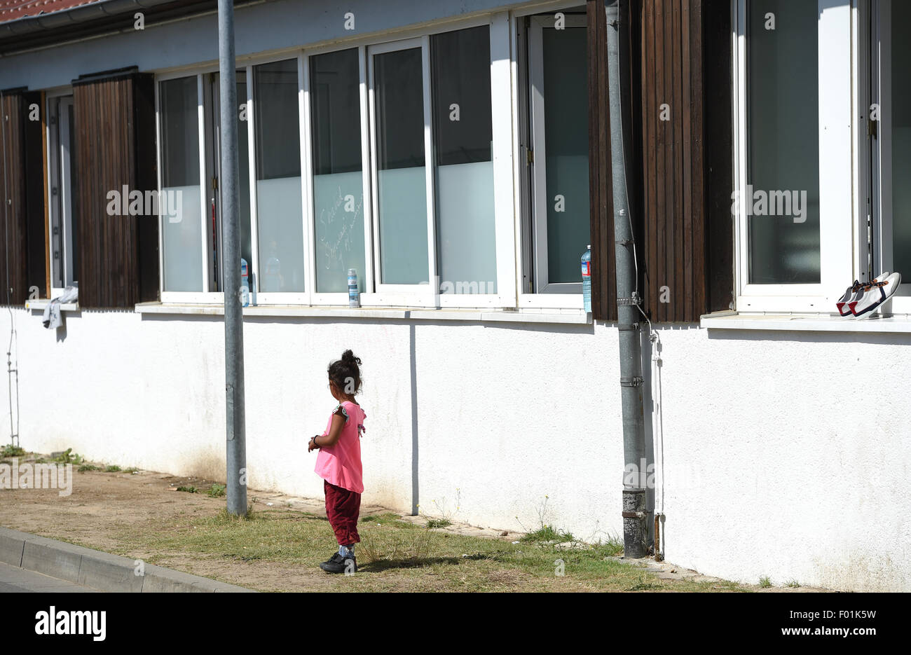 Ingelheim, Germany. 5th Aug, 2015. A child stands outside a building at ...