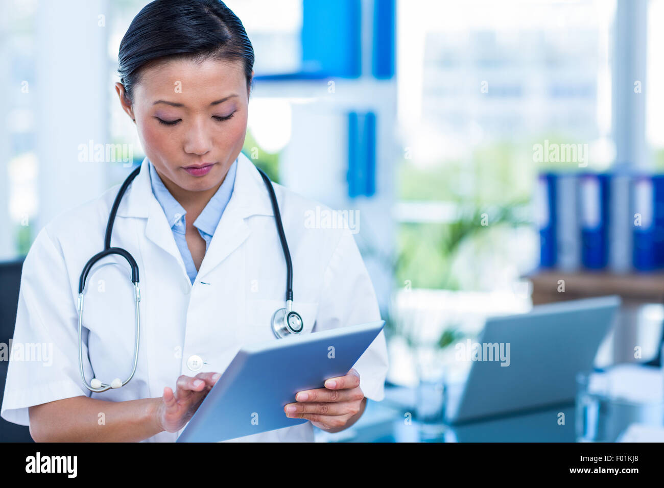 Serious doctor using tablet Stock Photo - Alamy
