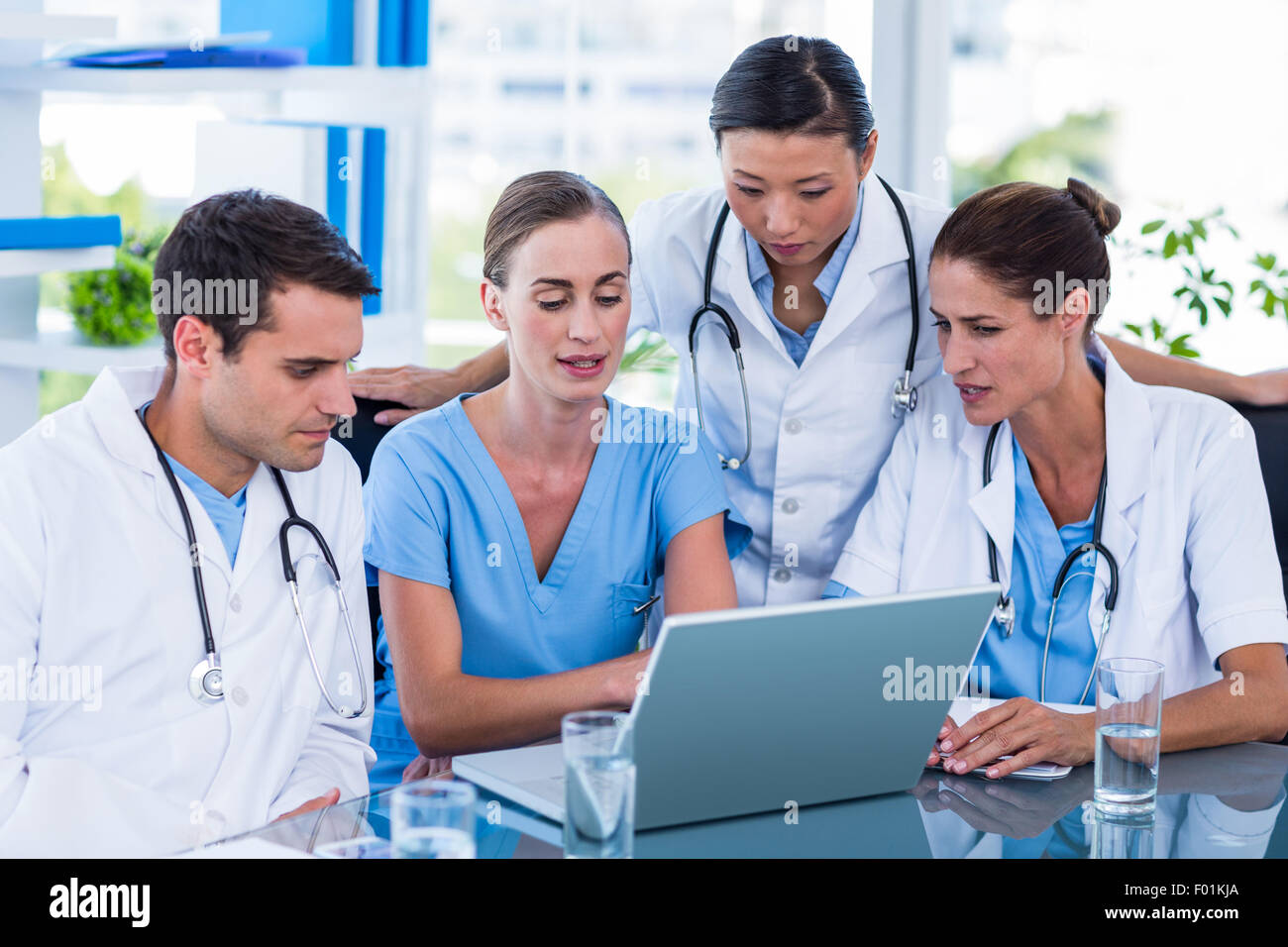 Team of doctors working on laptop Stock Photo - Alamy