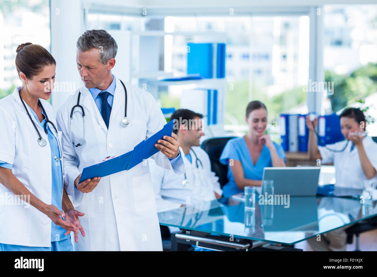 Doctors looking together at clipboard Stock Photo - Alamy