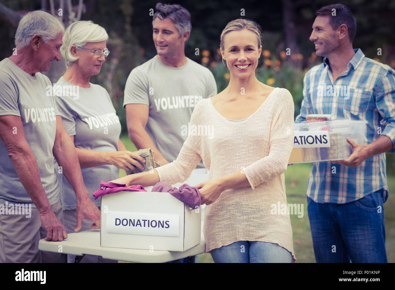 Happy volunteer family separating donations stuffs Stock Photo - Alamy