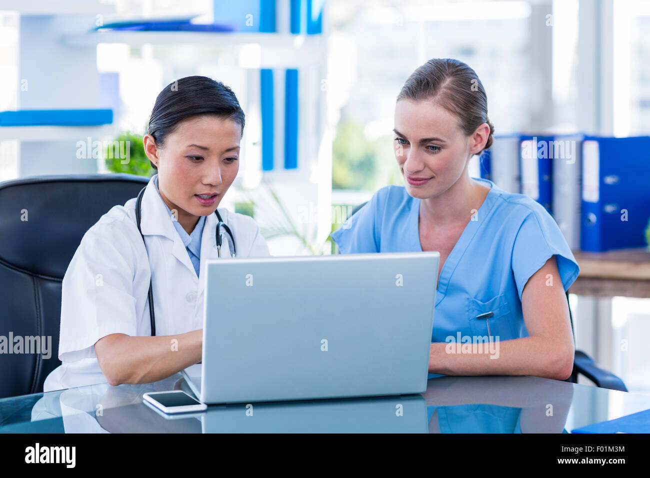 Doctor and nurse looking at laptop Stock Photo - Alamy
