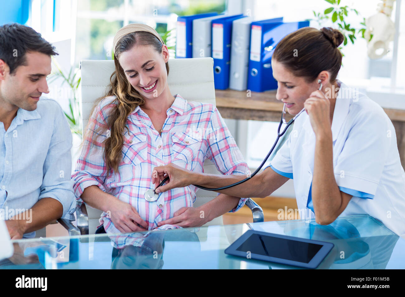 Doctor checking belly of pregnant woman with stethoscope Stock Photo ...