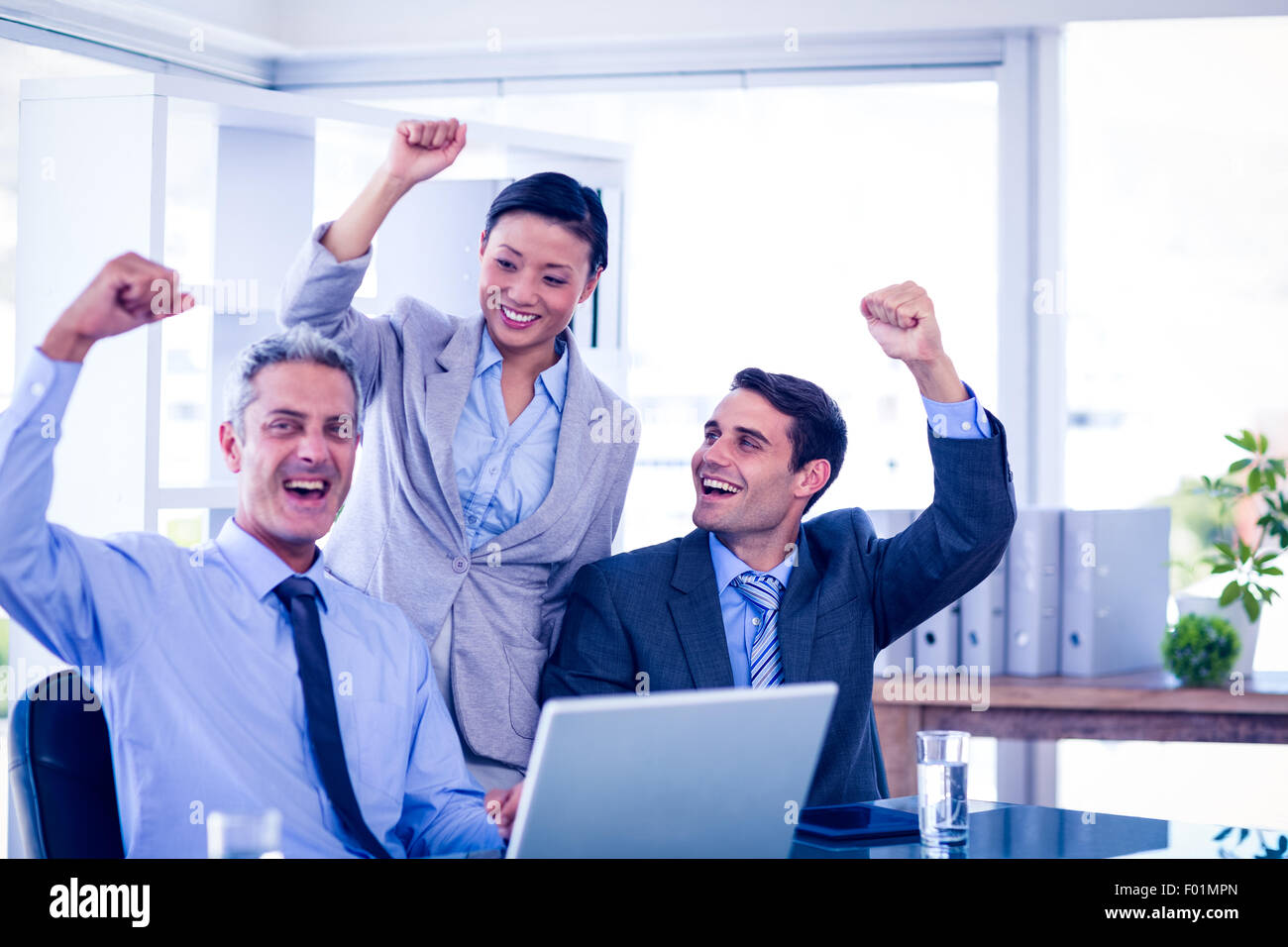 Happy business people cheering together Stock Photo - Alamy