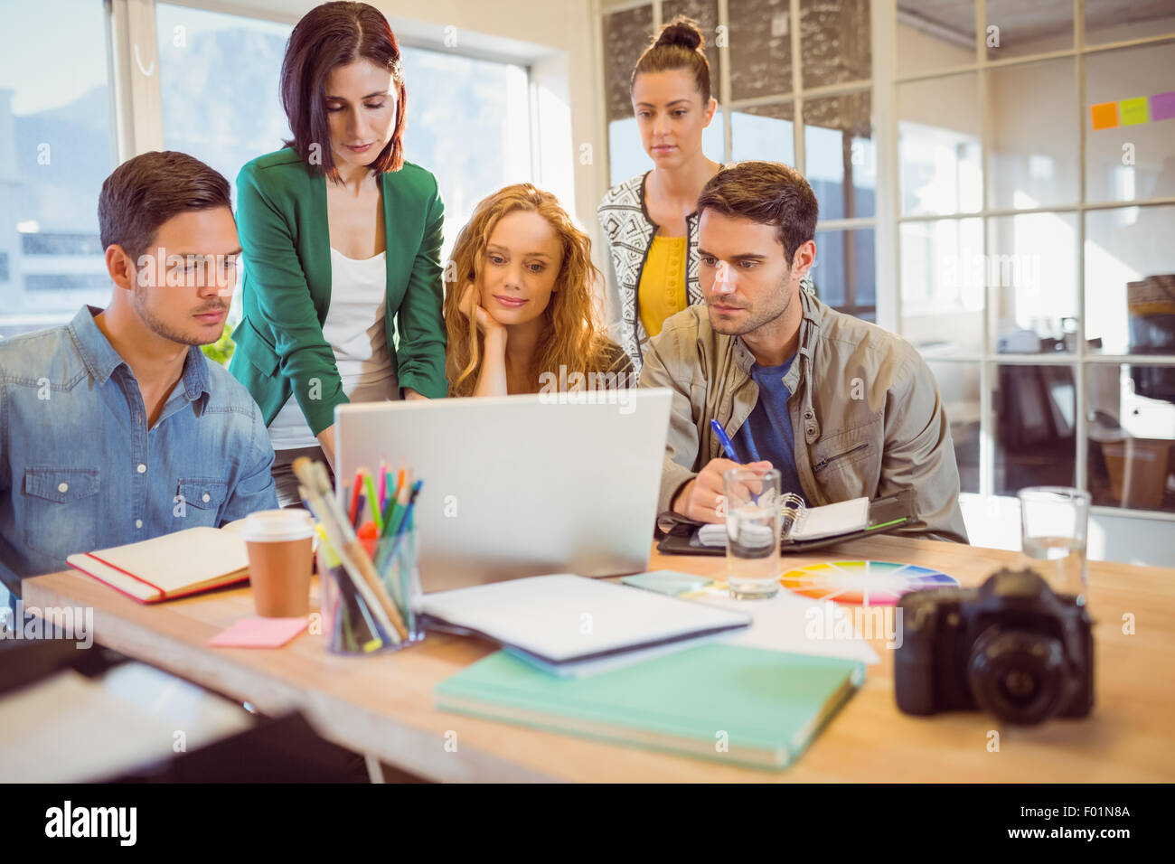Group of young colleagues using laptop Stock Photo - Alamy