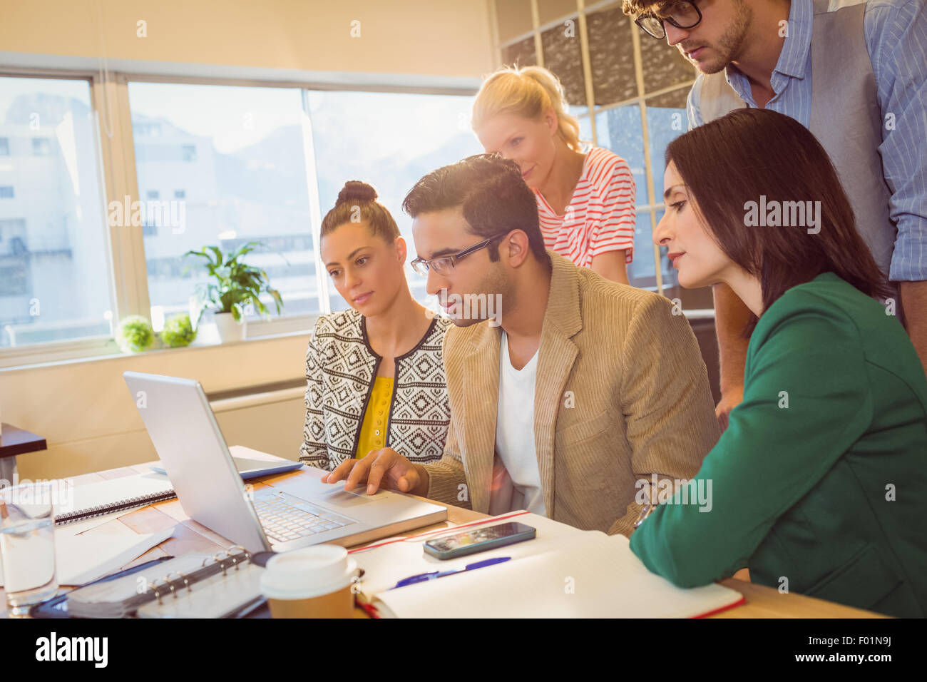 Colleagues using laptop in office Stock Photo - Alamy