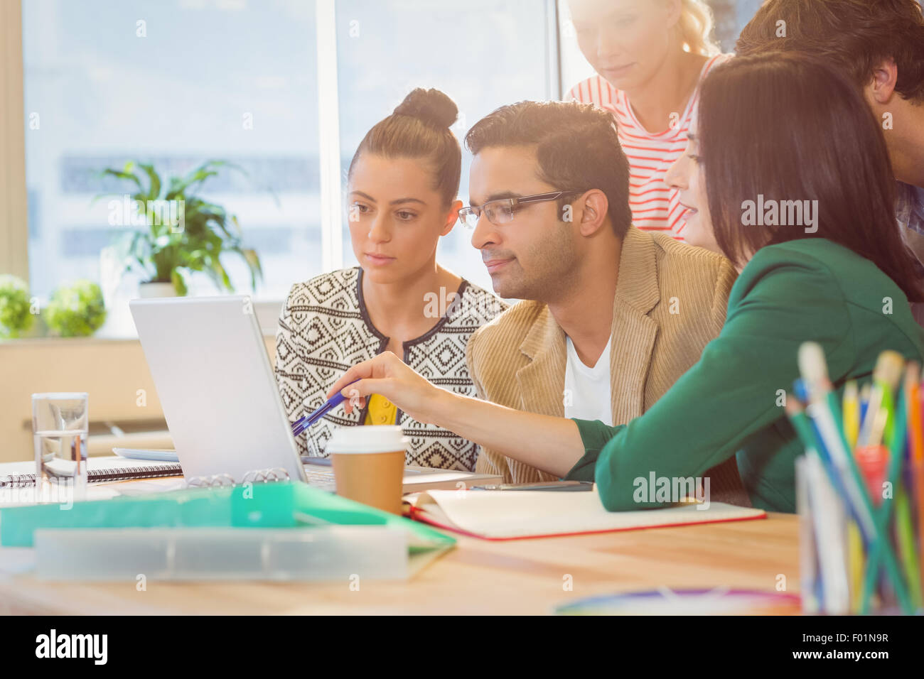 Colleagues using laptop in office Stock Photo - Alamy