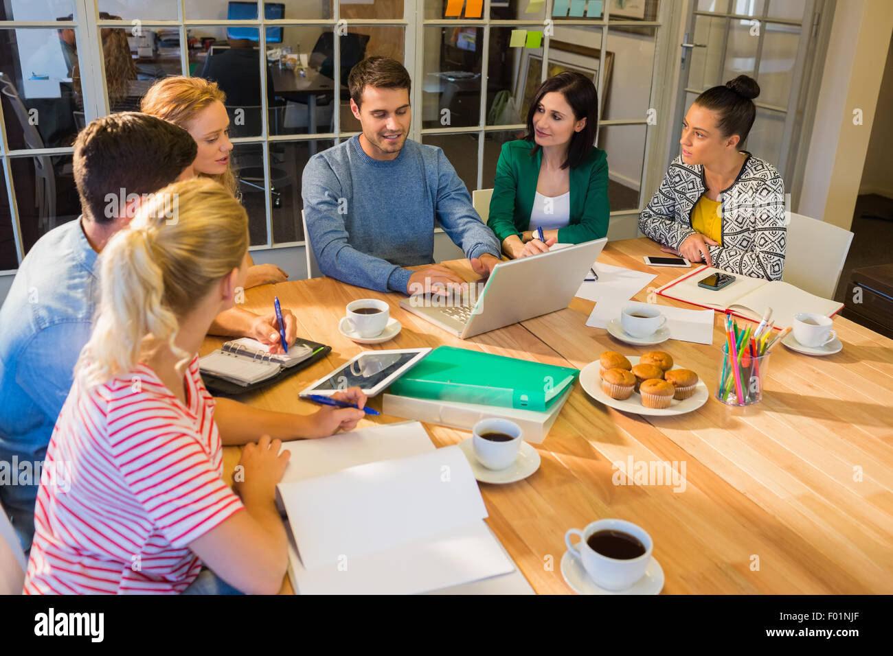 Colleagues using laptop at office Stock Photo - Alamy