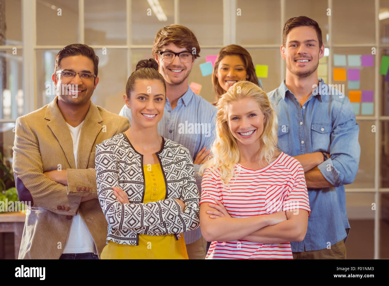 Happy business team smiling at camera with arms crossed Stock Photo - Alamy
