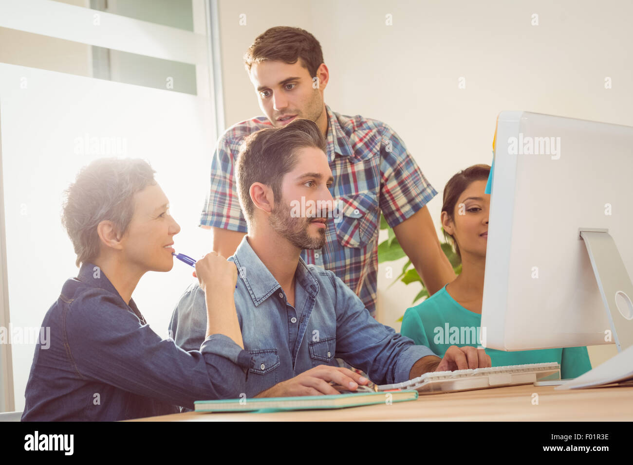 Colleagues using laptop at office Stock Photo - Alamy