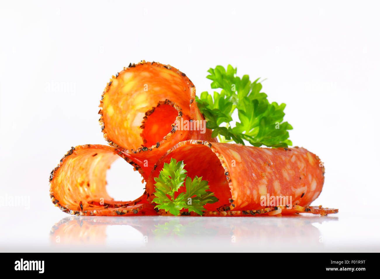 Thin slices of black pepper-coated salami speckled with pieces of Comte ...