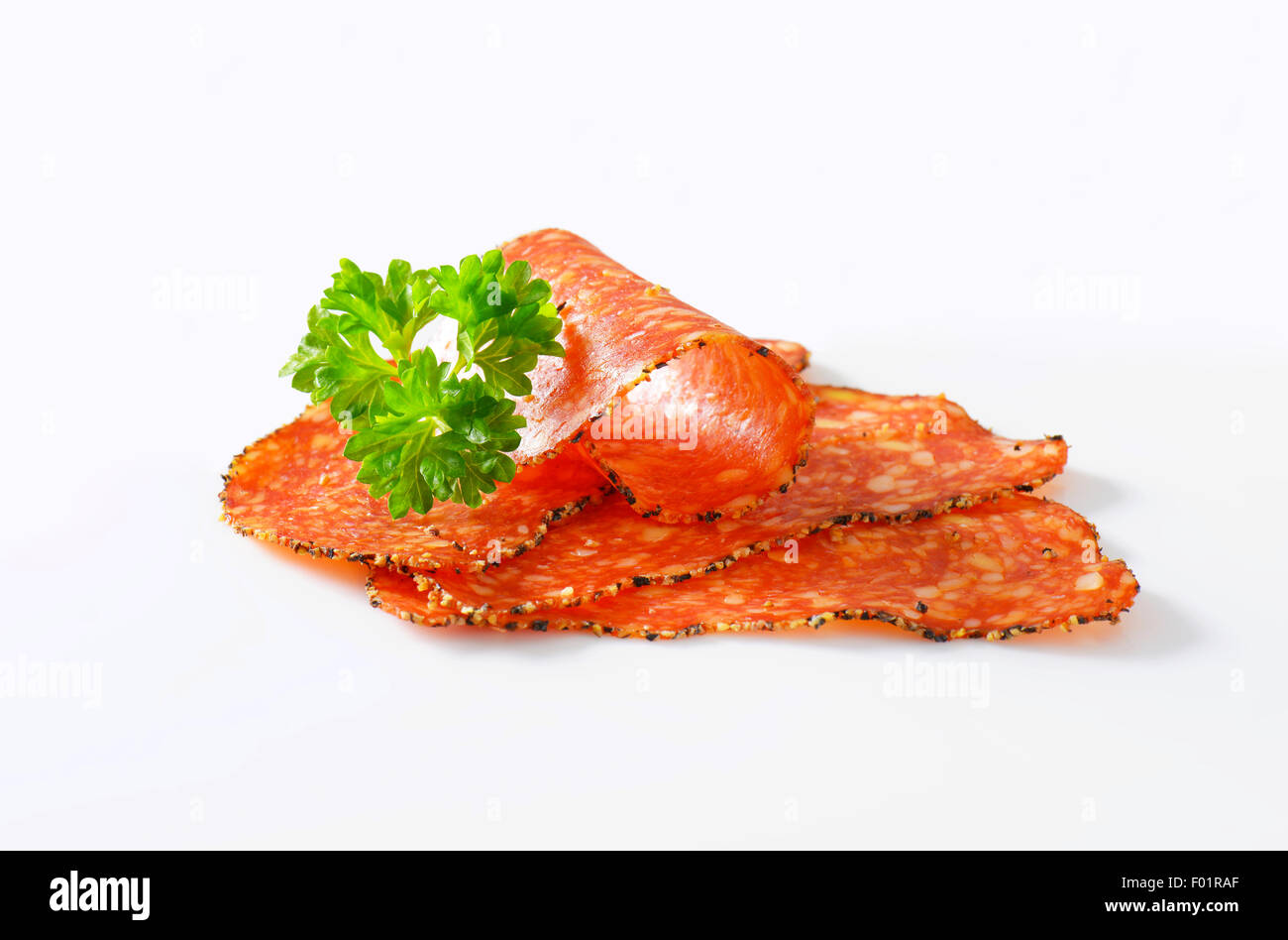 Thin slices of black pepper-coated salami speckled with pieces of Comte ...