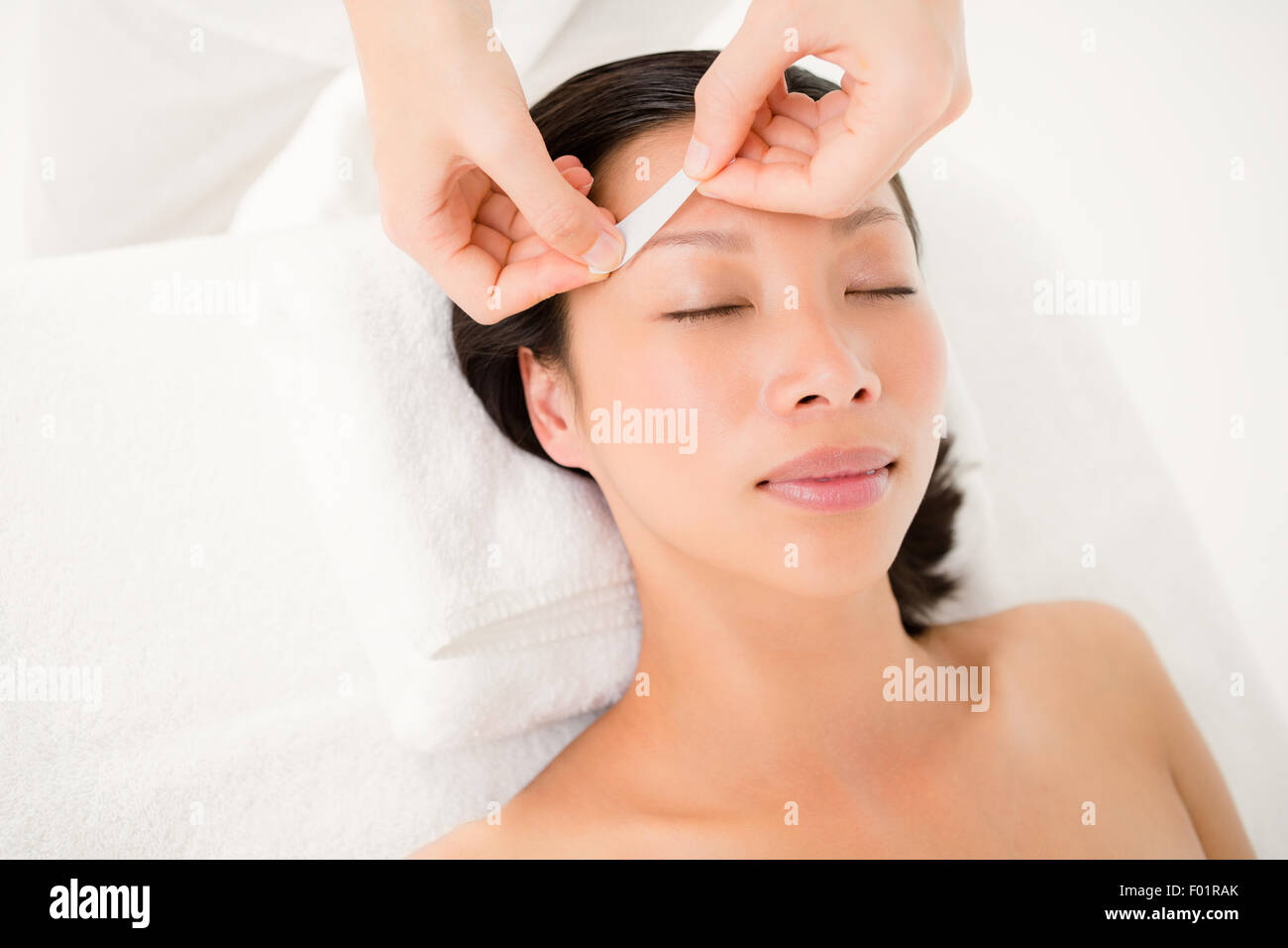 Hand waxing beautiful womans eyebrow Stock Photo - Alamy