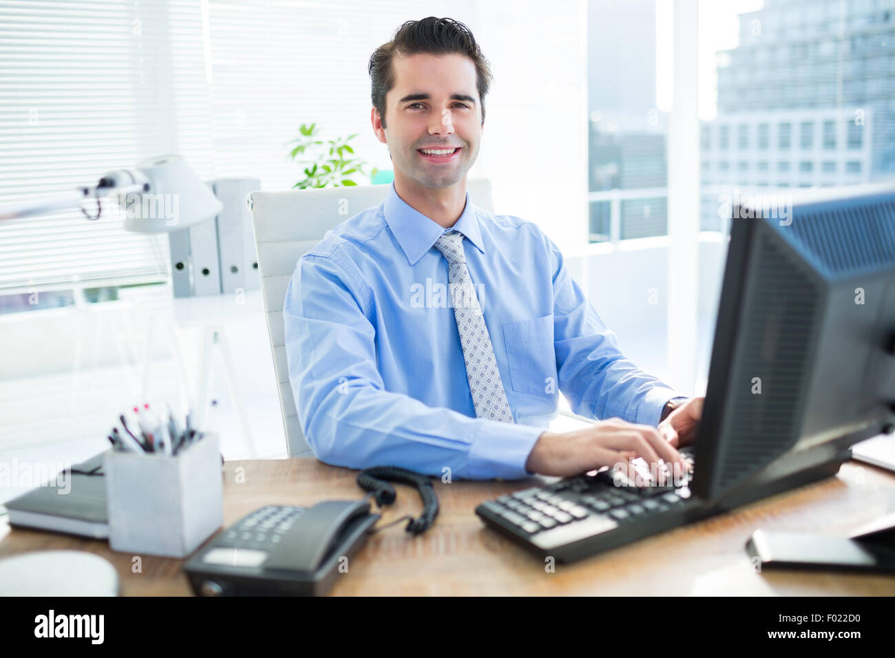 Smiling businessman using computer Stock Photo - Alamy