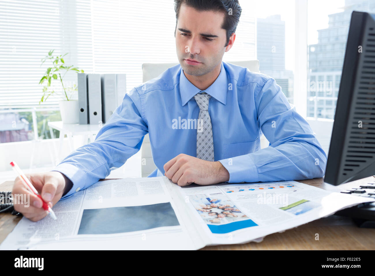 Cheerful businessman writing at his desk Stock Photo - Alamy