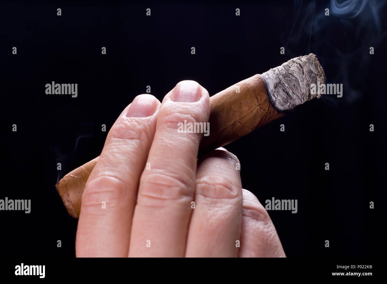 Male hand holding cigar Stock Photo - Alamy