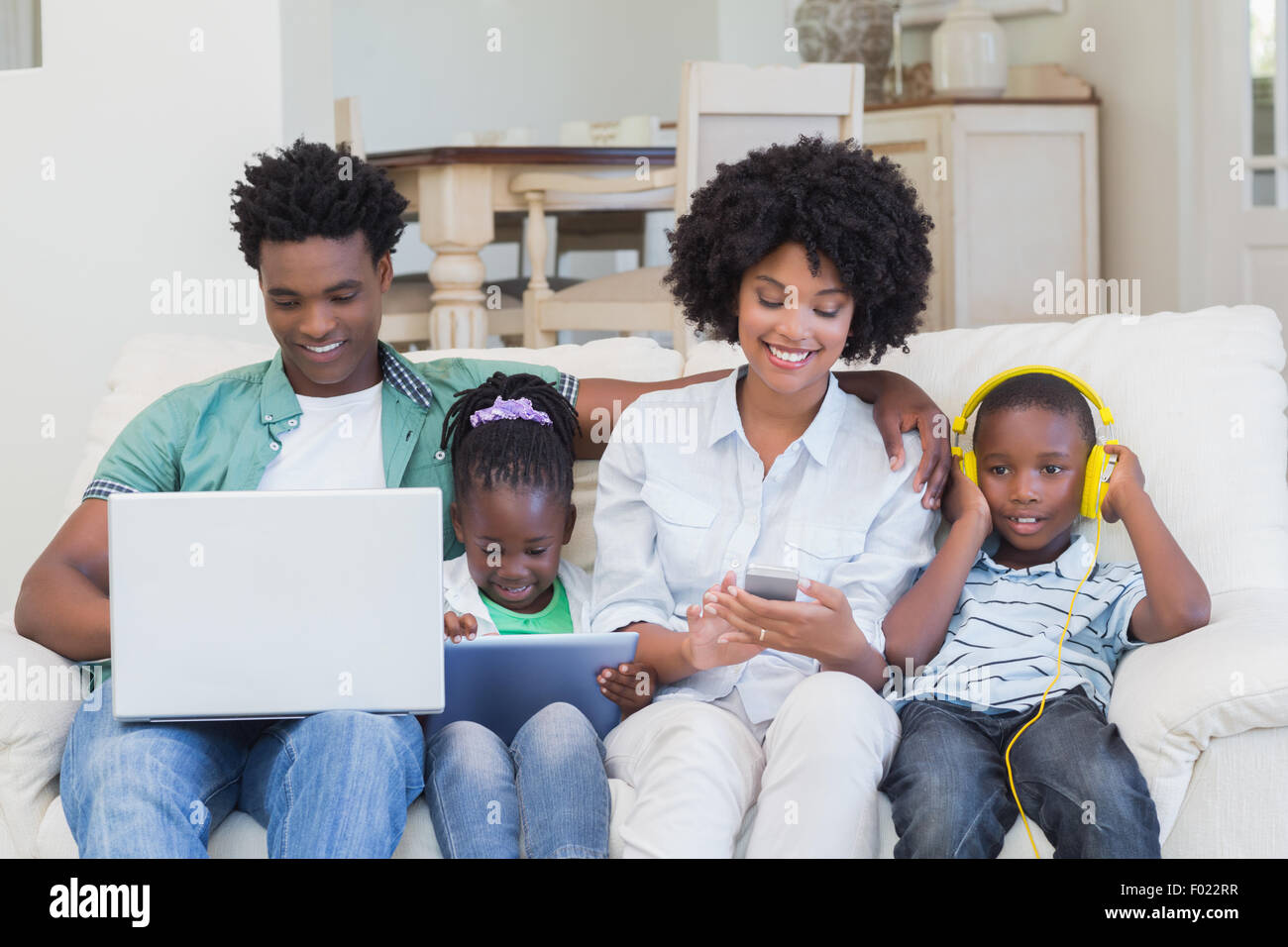 Happy family using technologies on the couch Stock Photo - Alamy