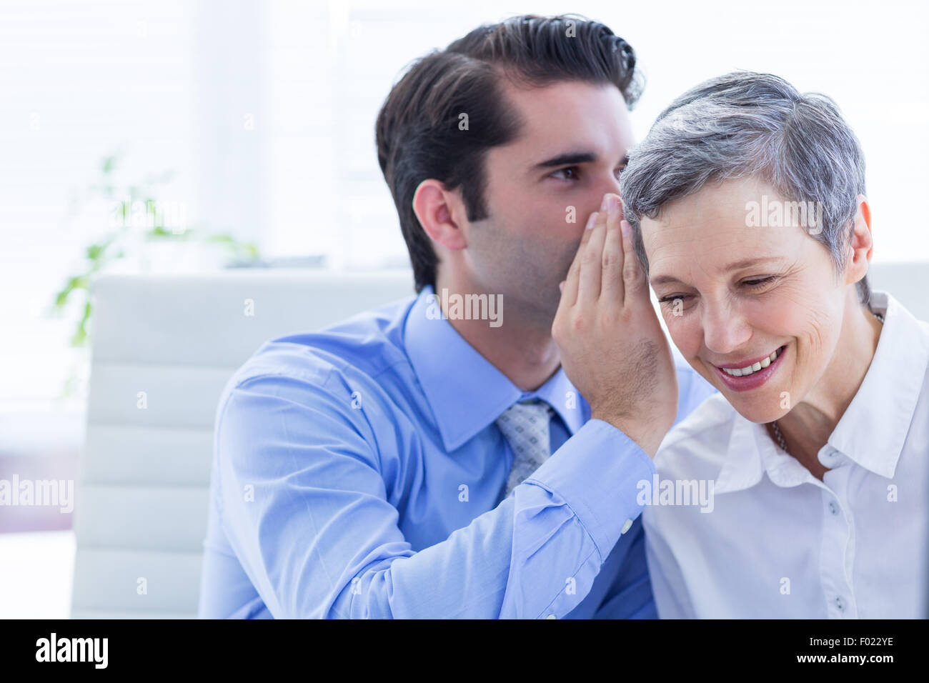 Two business people looking at a paper while working on folder Stock ...