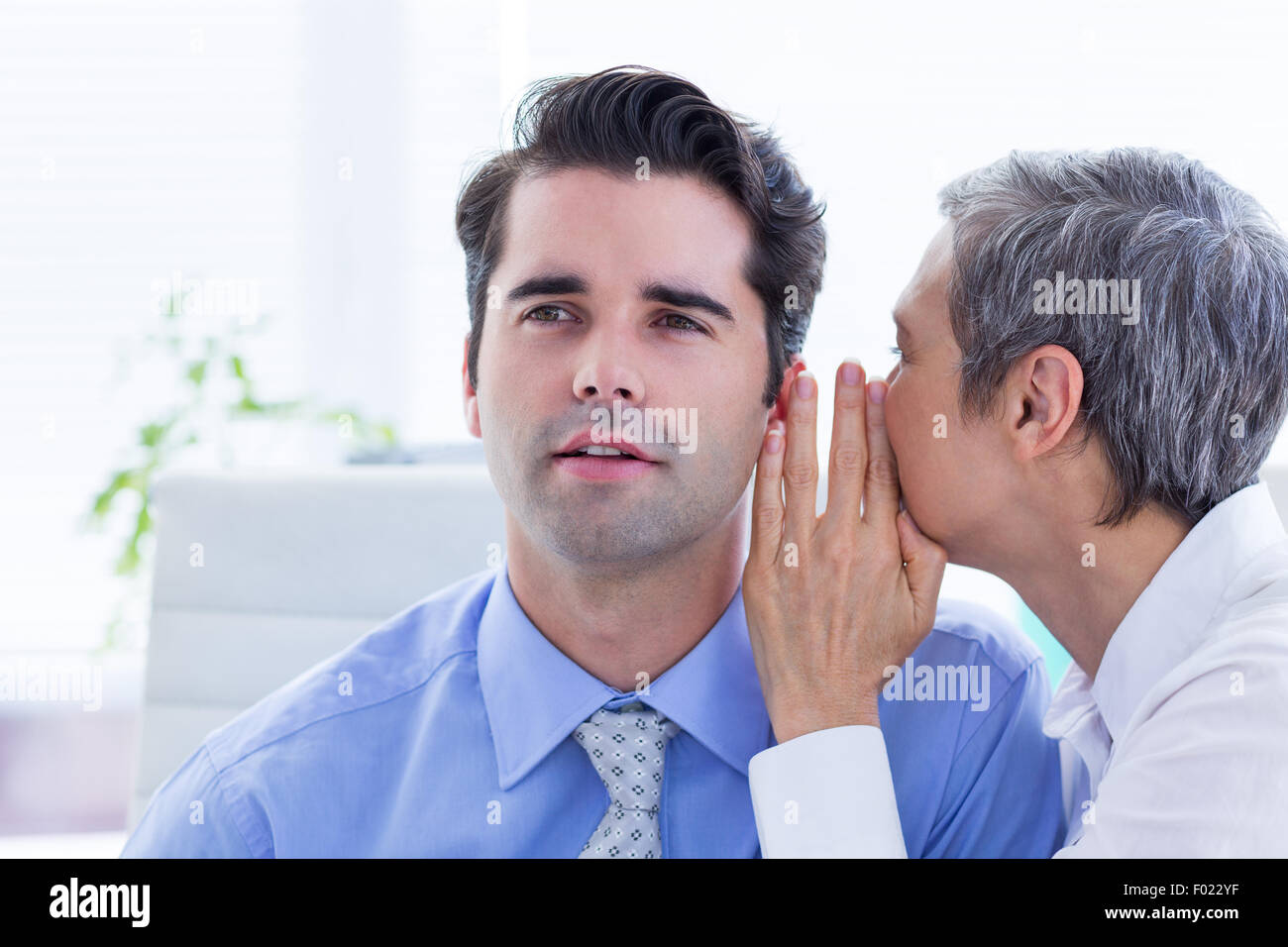 Two business people looking at a paper while working on folder Stock ...