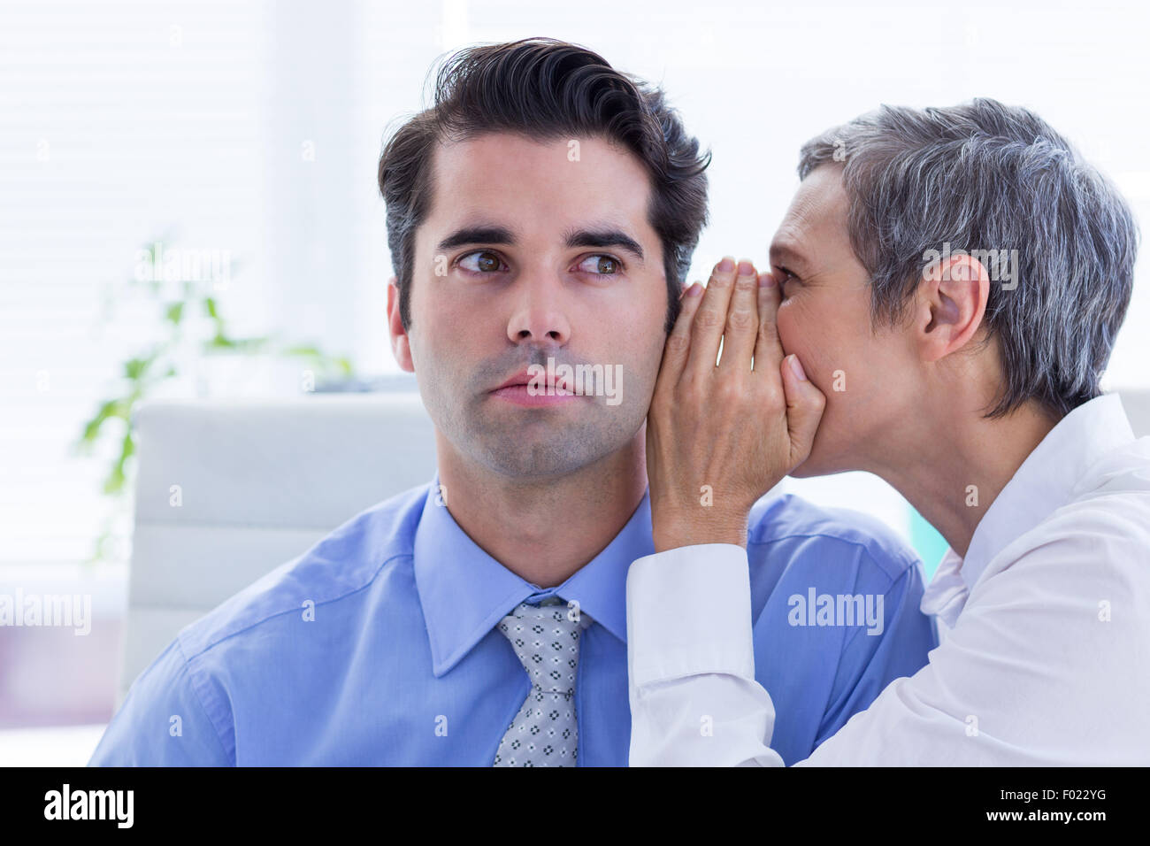 Two business people looking at a paper while working on folder Stock ...