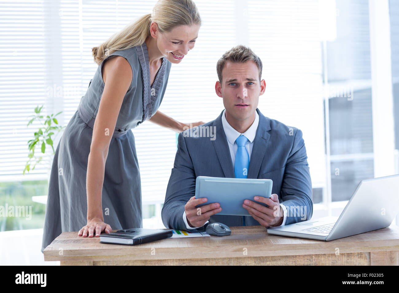 Serious colleagues working together on tablet Stock Photo - Alamy