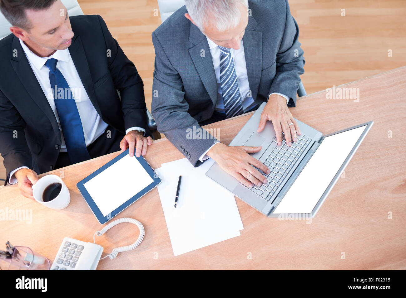High view of businessmen working together on laptop Stock Photo - Alamy