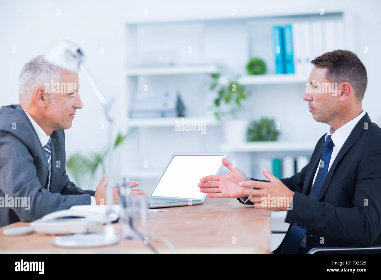 Two serious businessmen speaking and working Stock Photo - Alamy