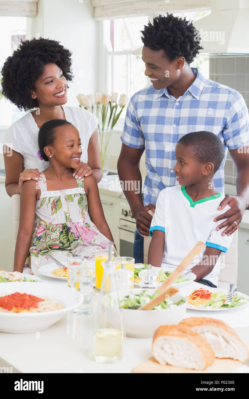 Happy family sitting down to dinner together Stock Photo - Alamy