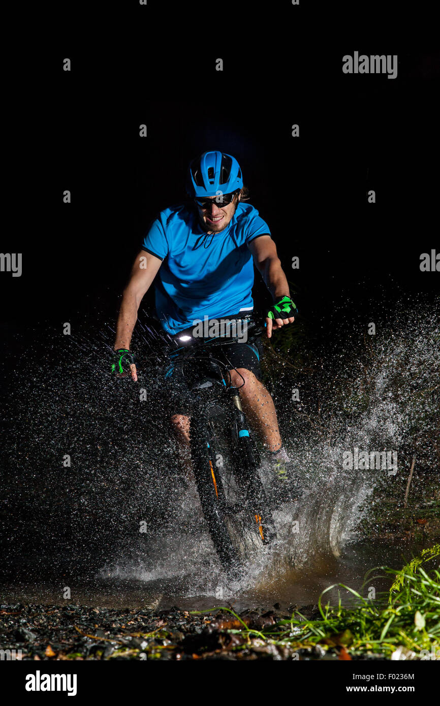 Mountain biker running through water Stock Photo - Alamy