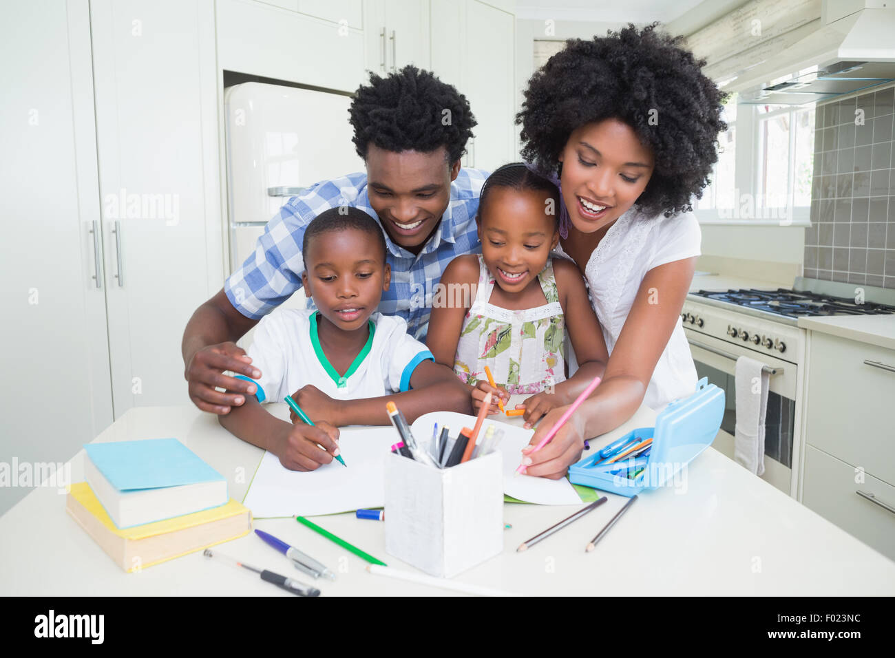 Happy parents helping children with homework Stock Photo - Alamy