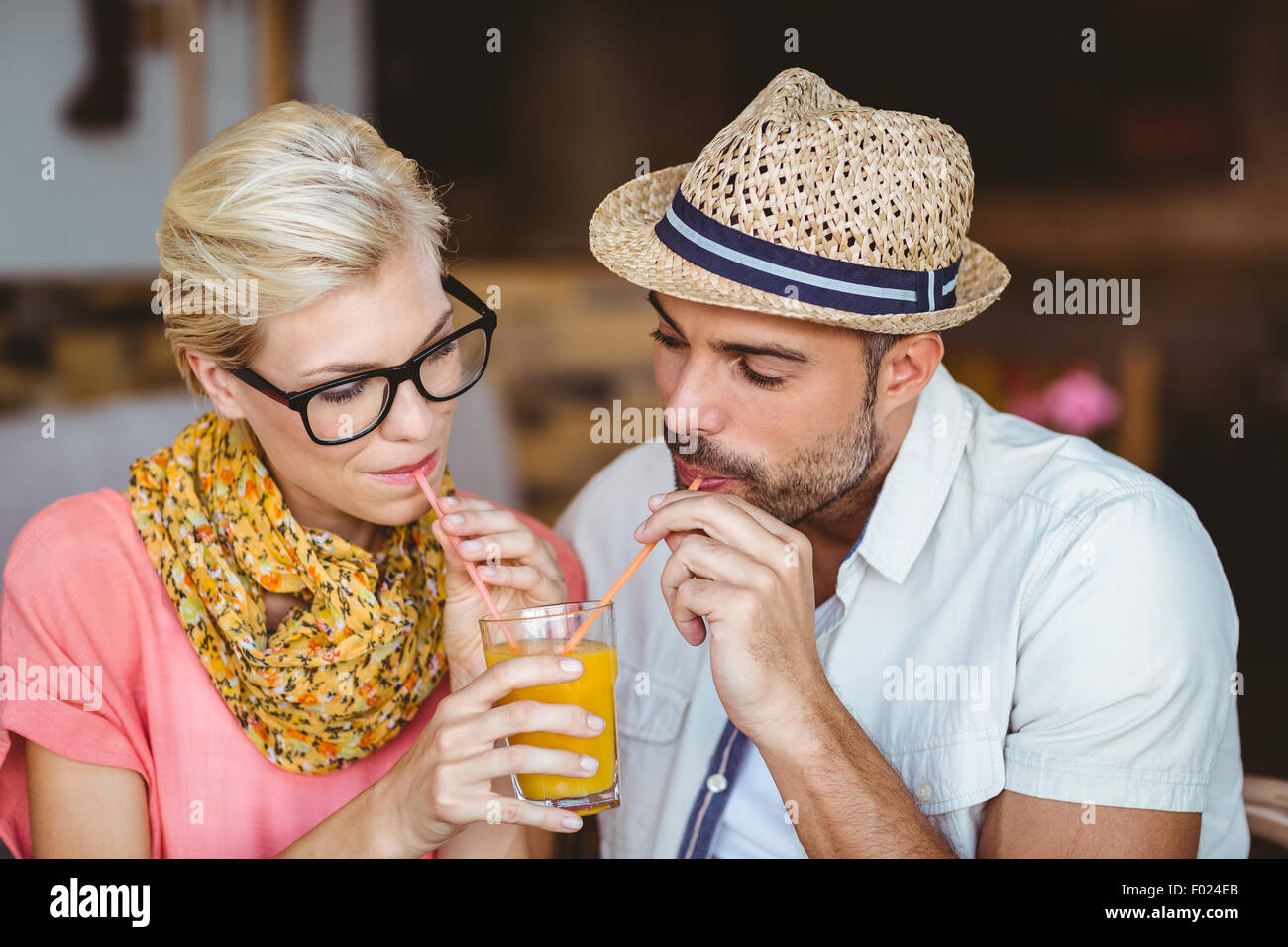 Cute couple on a date sharing an orange juice Stock Photo - Alamy