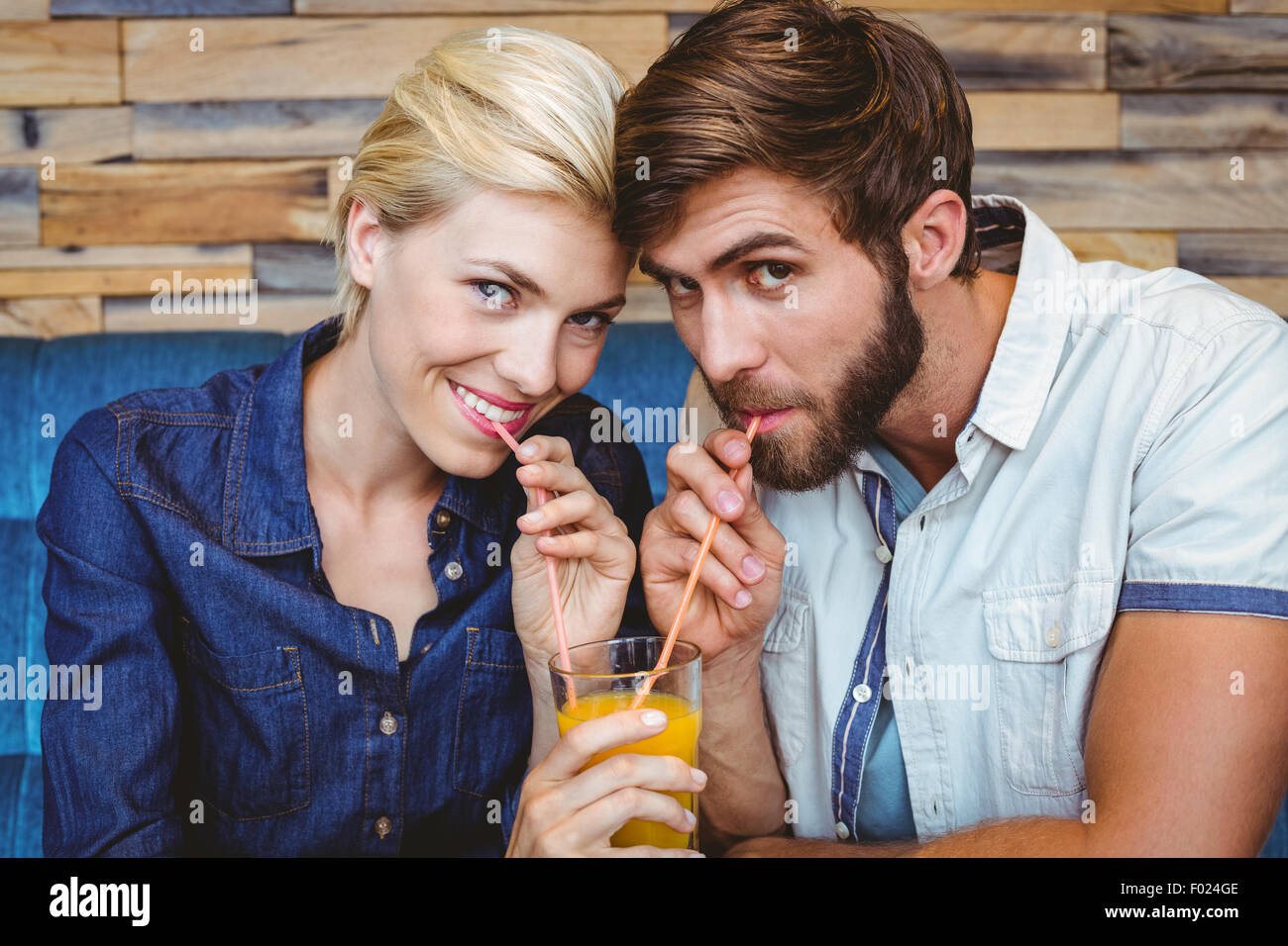 Cute couple on a date sharing a glass of orange juice Stock Photo - Alamy
