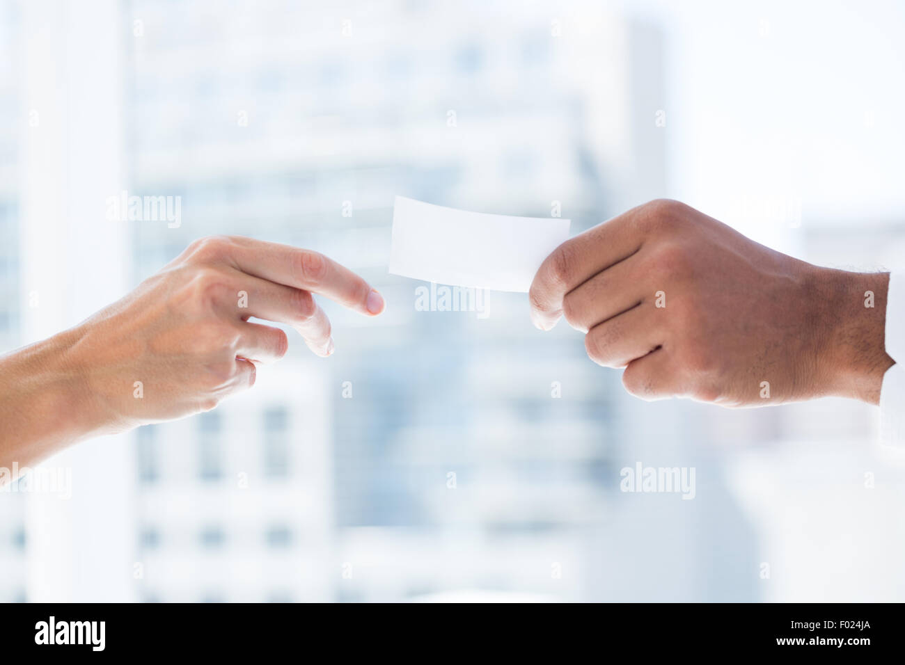 Hands giving small paper sheet to another one Stock Photo - Alamy