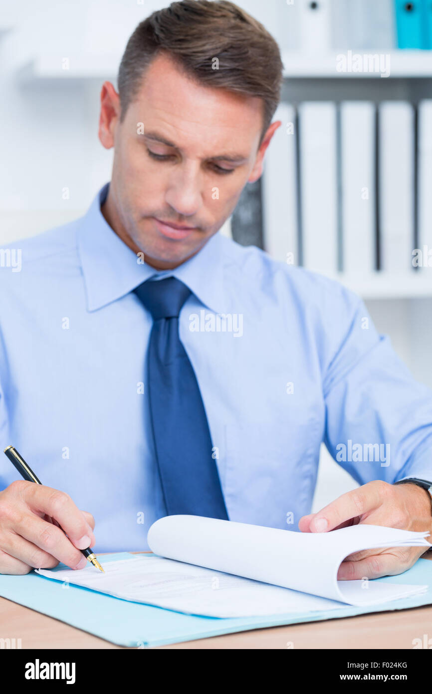 Smiling businessman reading a contrat before signing it Stock Photo - Alamy