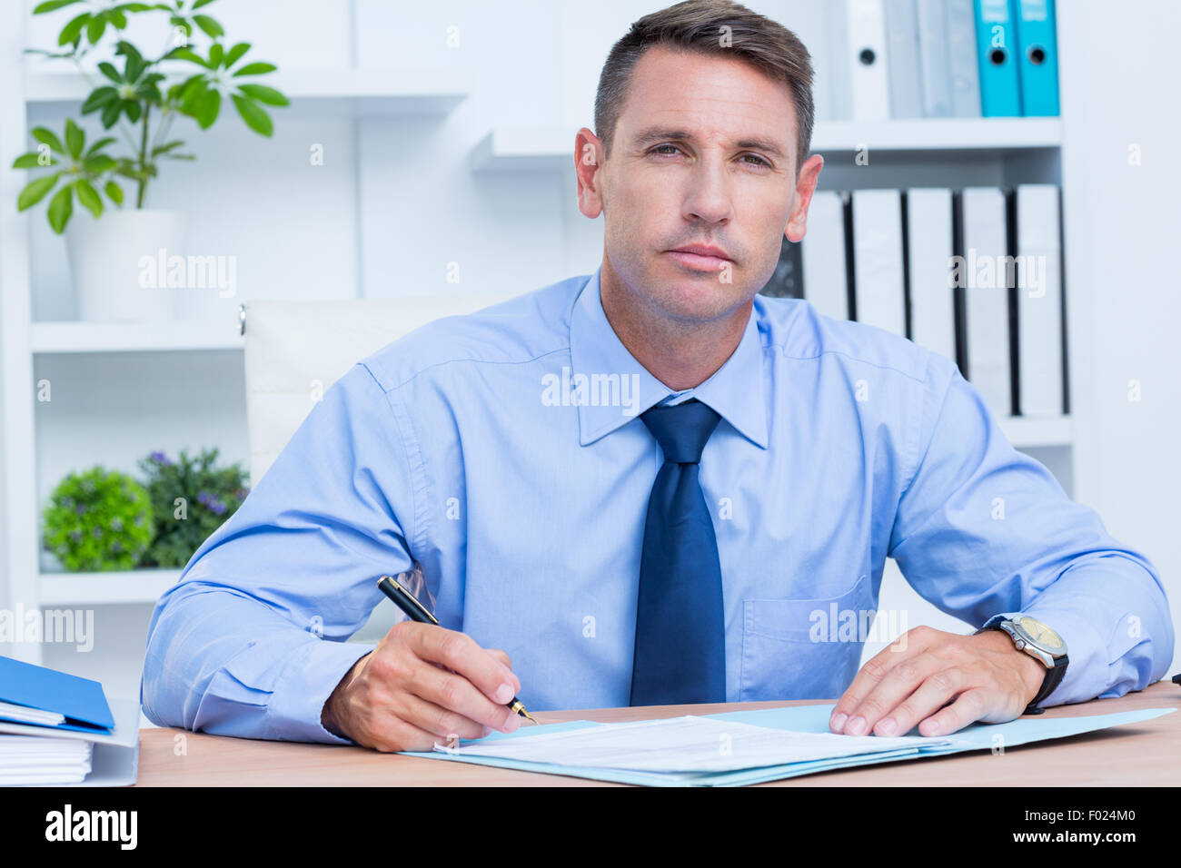 Portrait of serious businessman writing Stock Photo - Alamy
